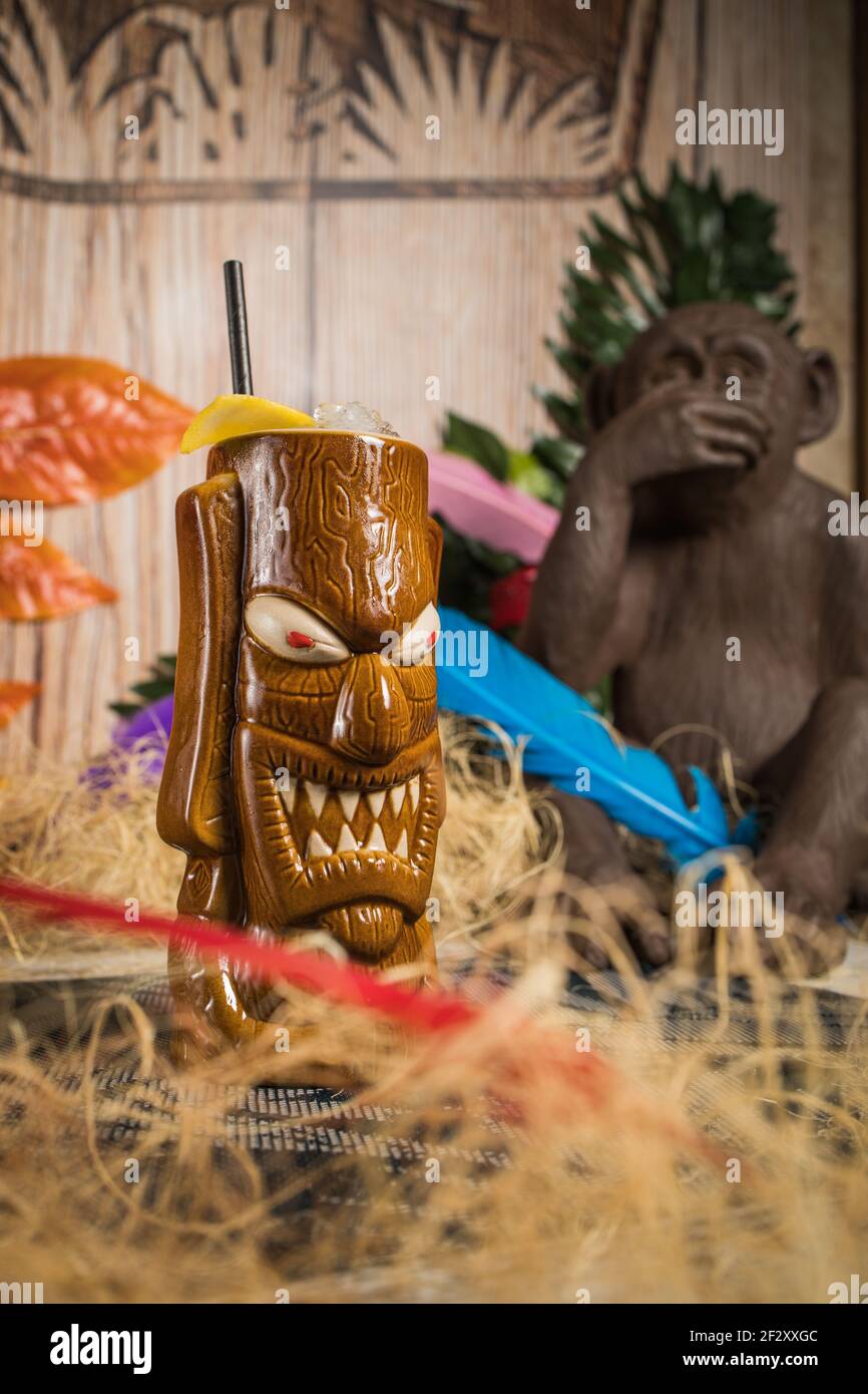 Brown sculptural tiki mug with alcohol drink decorated with straw and ...