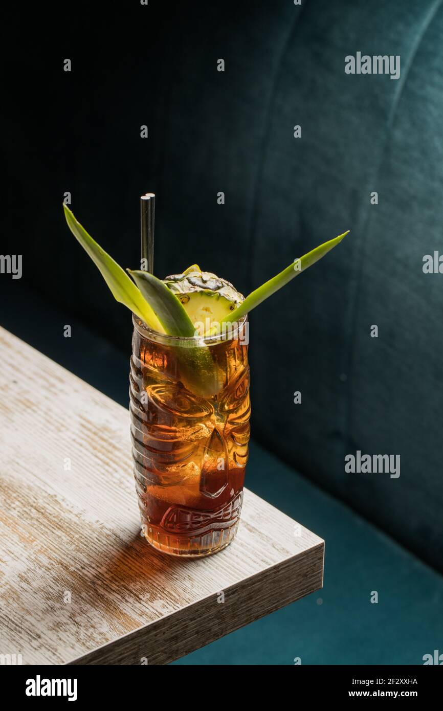 From above of glass tiki mug filled with alcohol beverage with straw ...