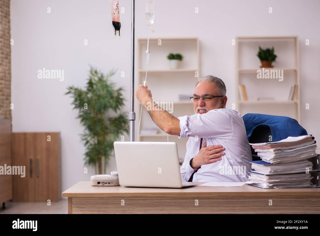 Old businessman employee in blood transfusion concept Stock Photo - Alamy