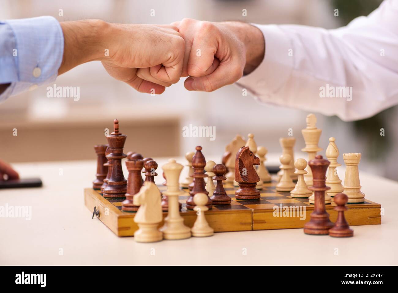Two male employees playing chess at workplace Stock Photo - Alamy