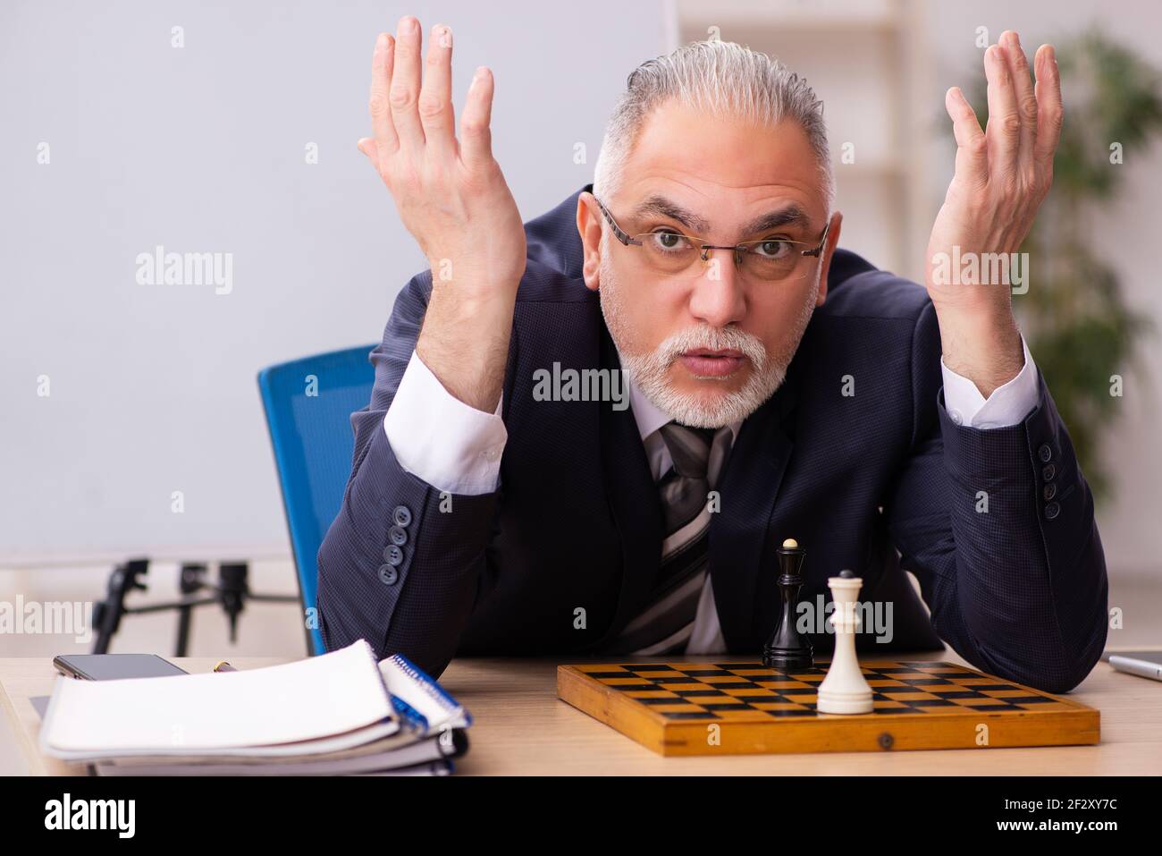 Old businessman employee playing chess at workplace Stock Photo - Alamy