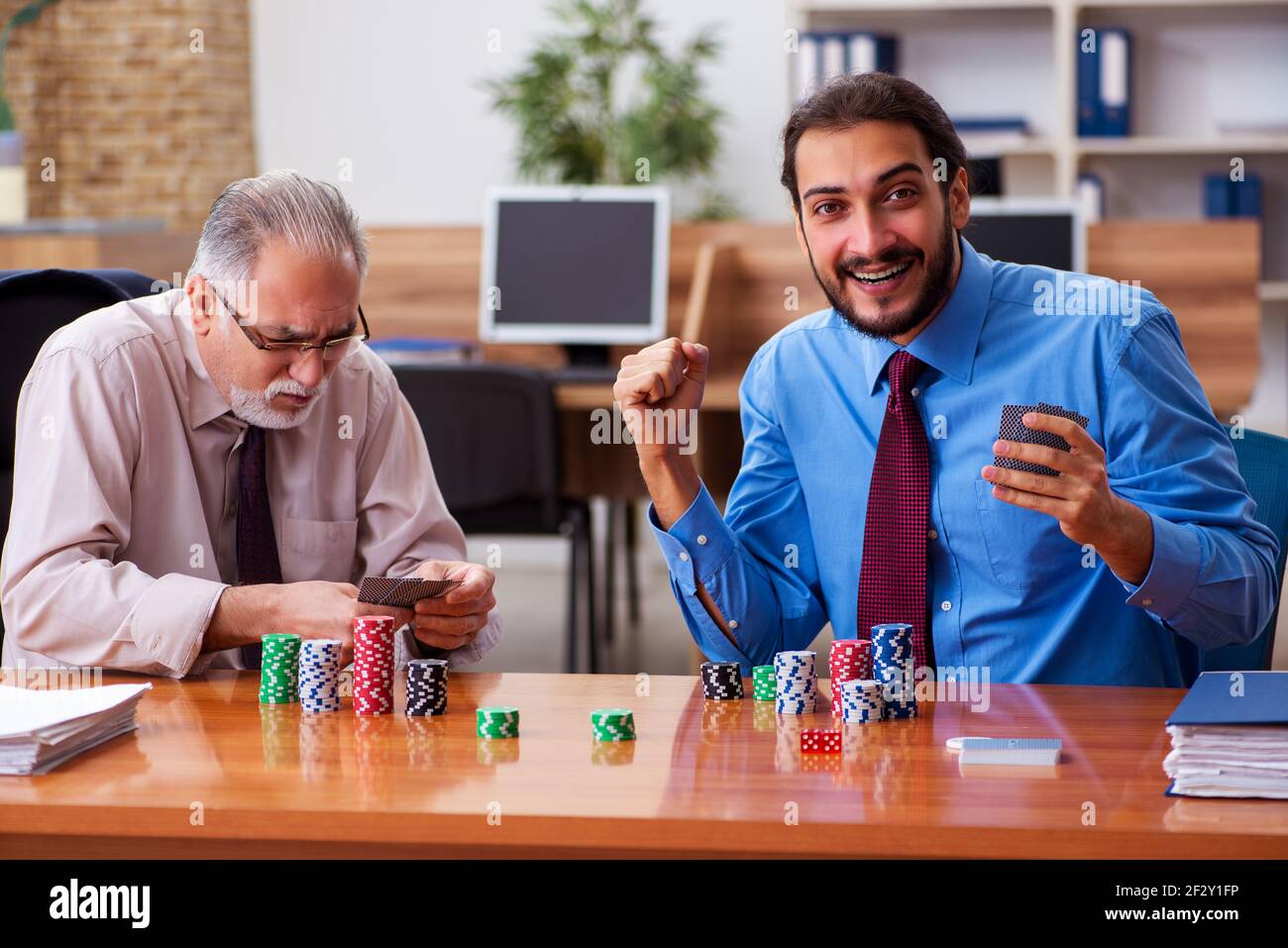 Two employees playing cards at workplace Stock Photo - Alamy