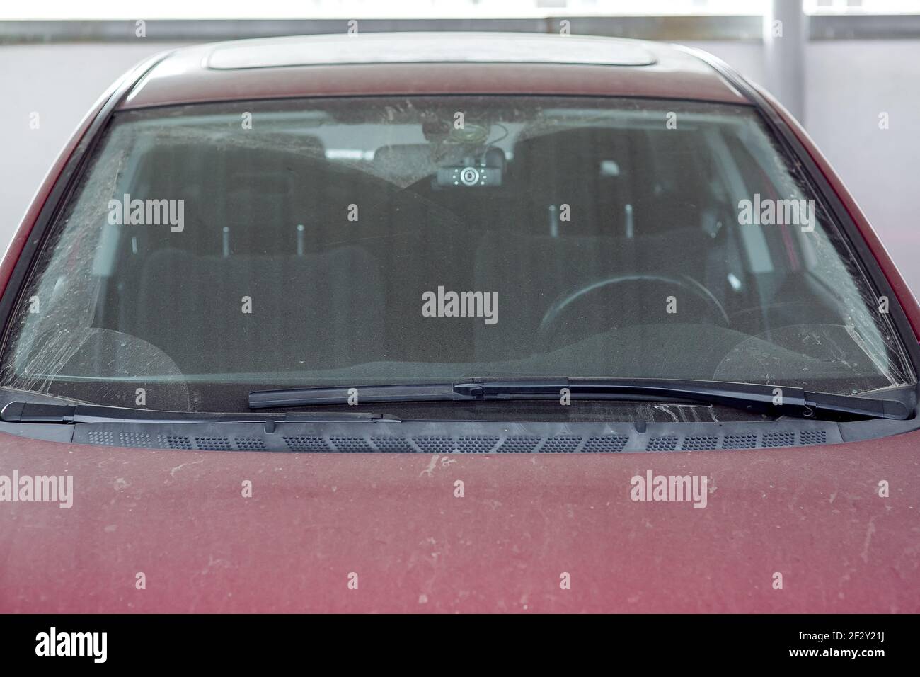 dirty red car windscreen wipers covered with a layer of dust, abandoned ...
