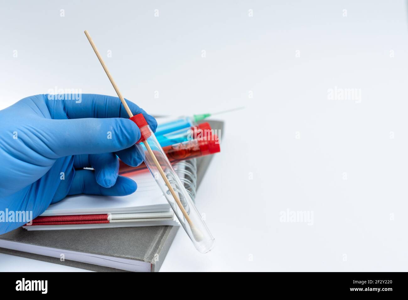 Doctor s hand with medical glove holding a blood probe in front of a ...