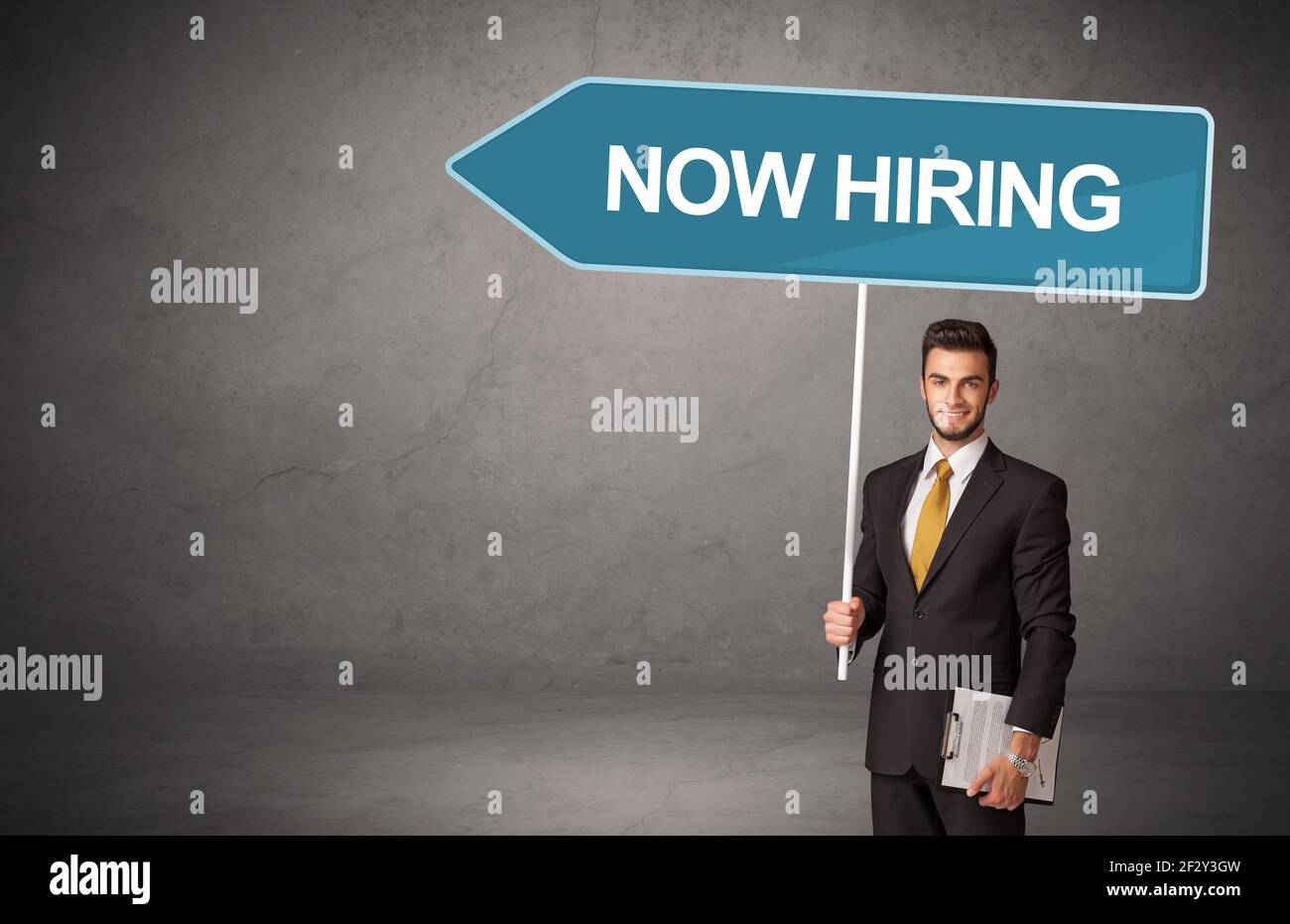 Young business person in casual holding road sign Stock Photo - Alamy