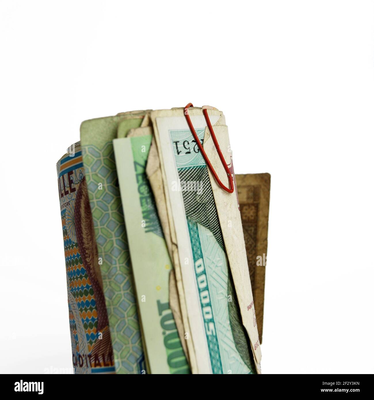 A roll of banknotes with a red clip isolated on a white background ...