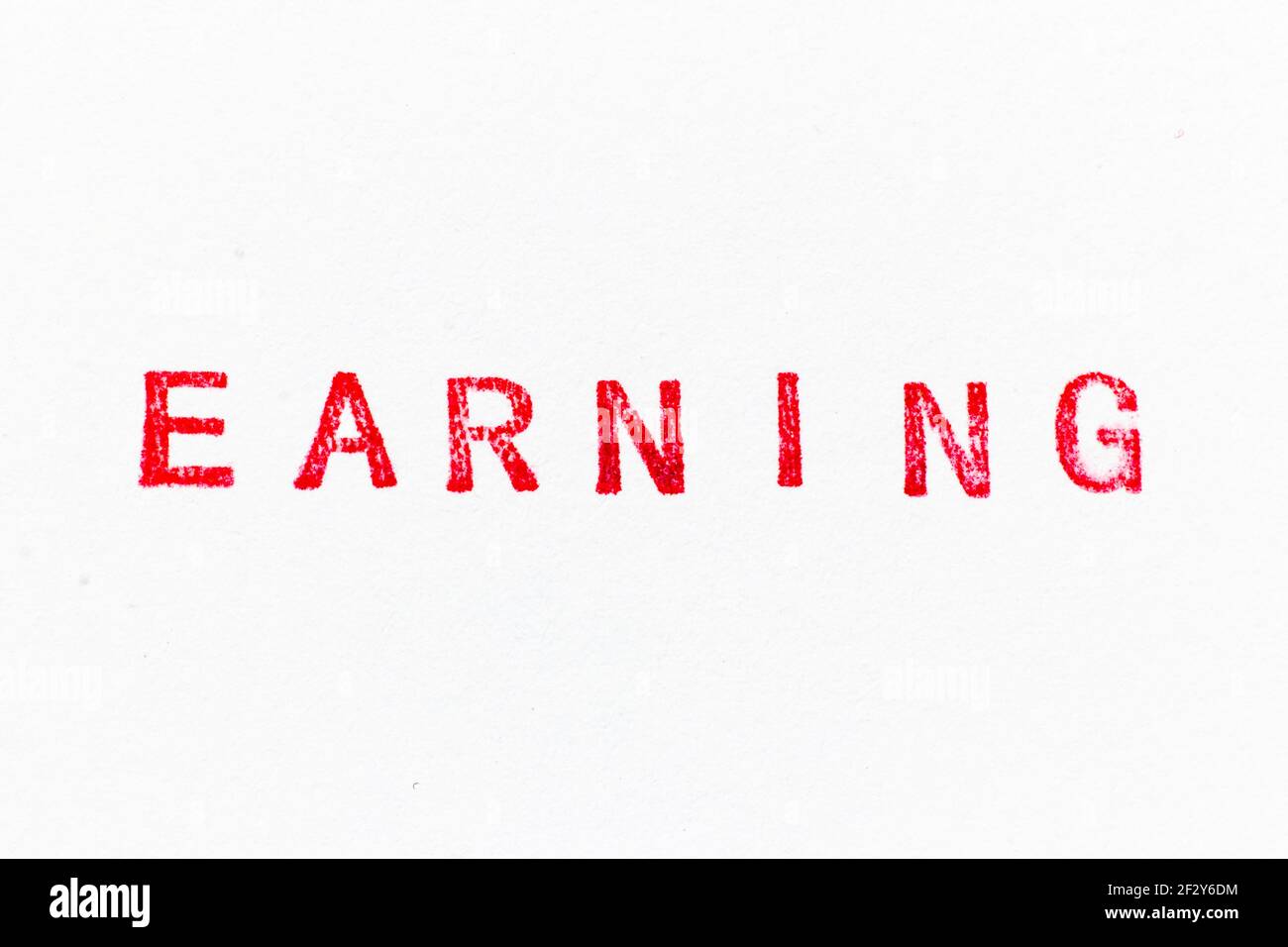 Red color ink rubber stamp in word earning on white paper background ...