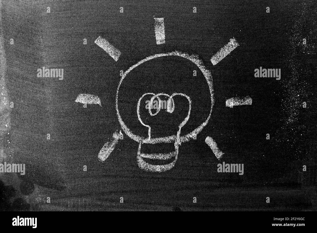 White chalk hand drawing in light bulb shape on blackboard or ...