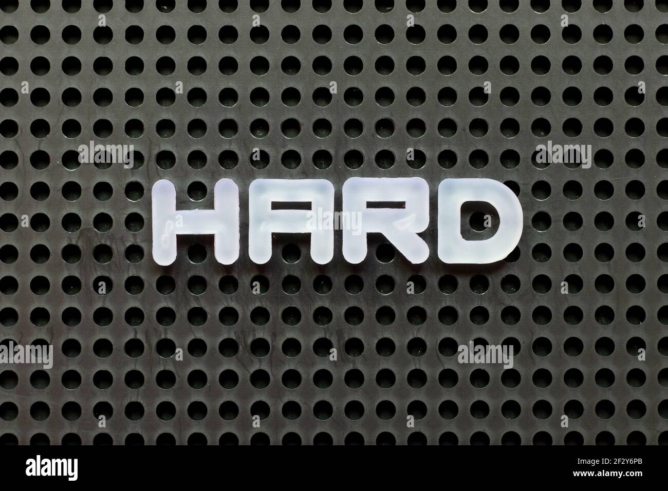 White color letter in word hard on black pegboard background Stock ...