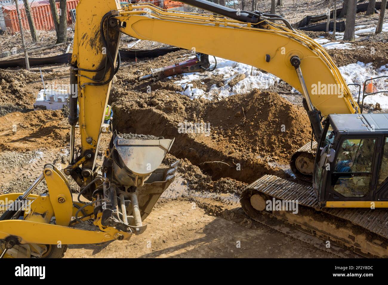 Excavator dig trench at construction site laying sewer wells and sewer ...