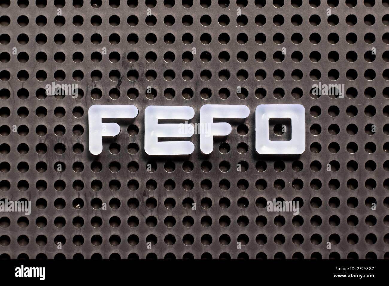 White color letter in word FEFO (first expired first out) on black ...