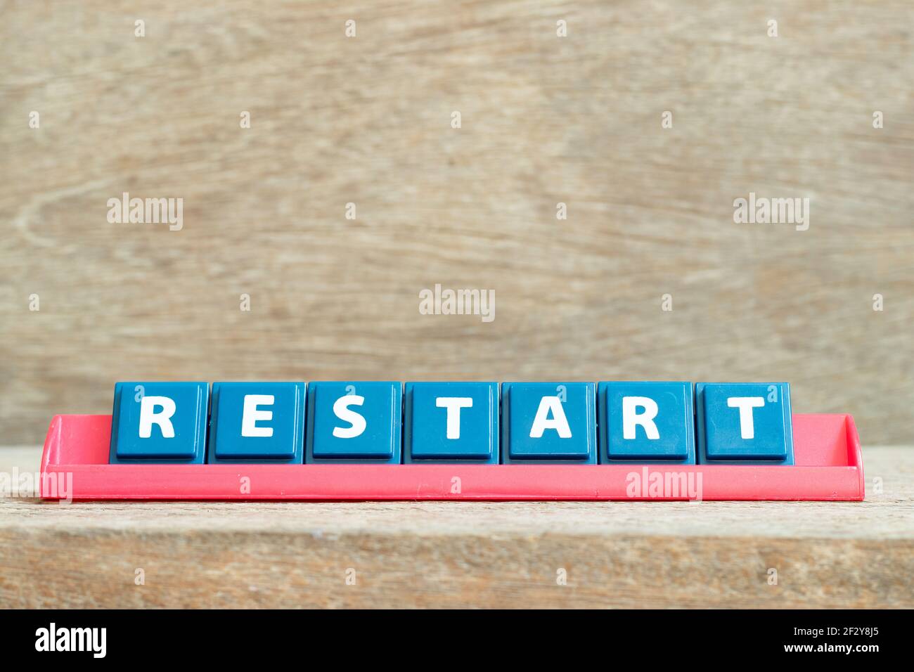 Tile alphabet letter with word restart in red color rack on wood ...