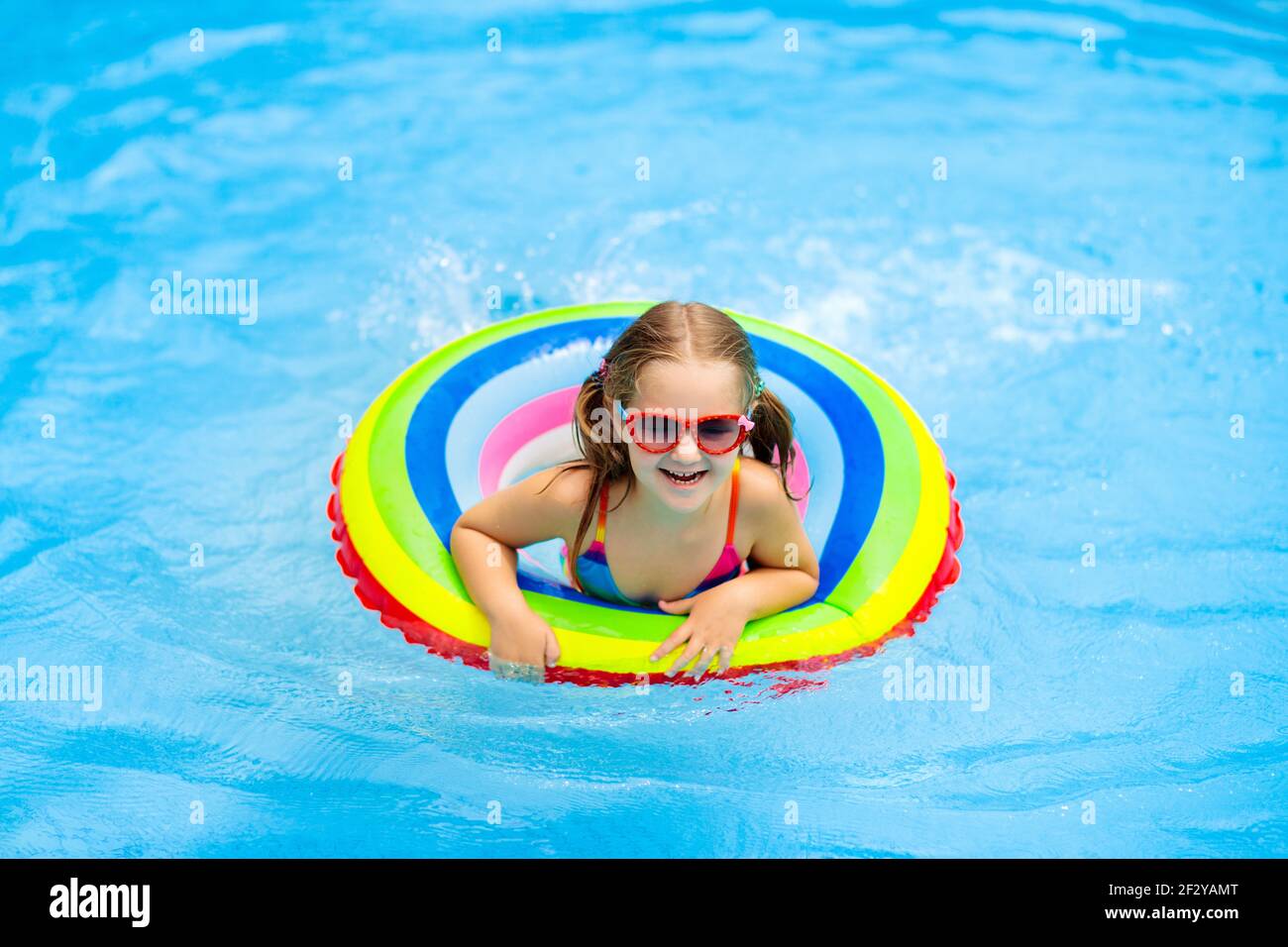 Child in swimming pool floating on toy ring. Kids swim. Colorful ...