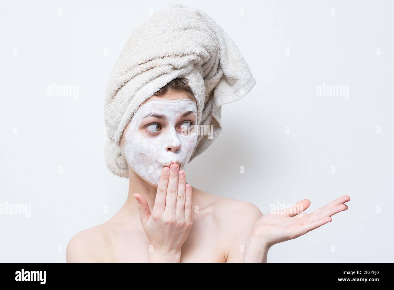 woman with a towel on her head and a moisturizer on her face Stock ...