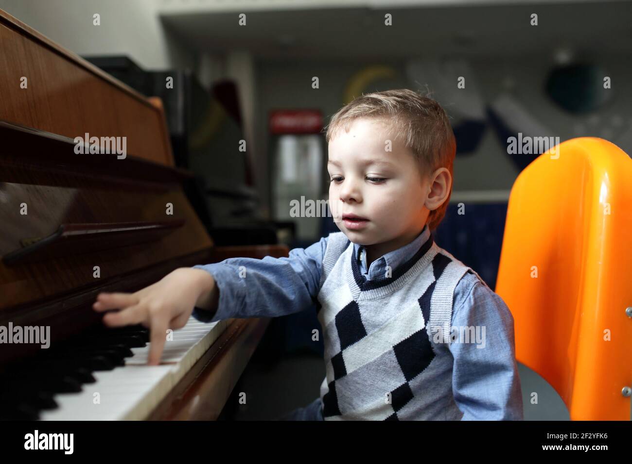 Child learning to play the piano at a classroom Stock Photo - Alamy