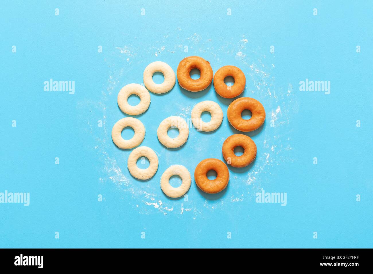 Making donuts recipe. Uncooked yeast-raised dough in circle shape and ...