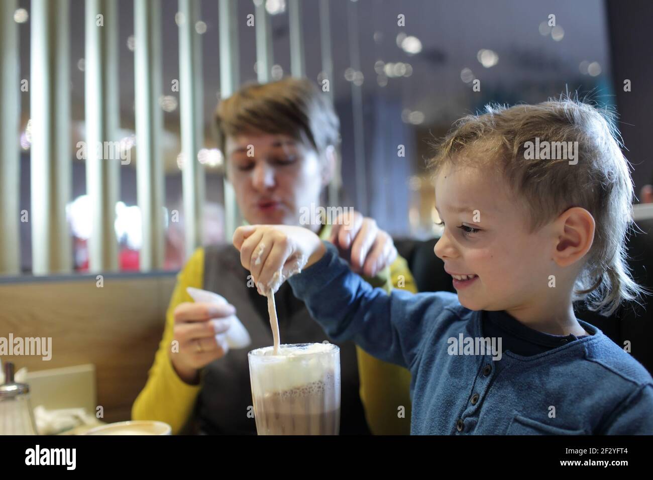 Boy eating foam of milkshake in the restaurant Stock Photo - Alamy
