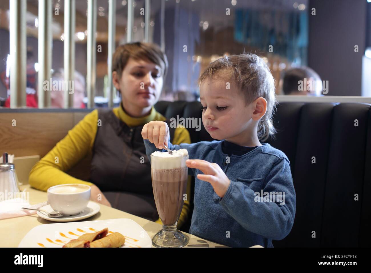 Child eating foam of milkshake in the restaurant Stock Photo - Alamy
