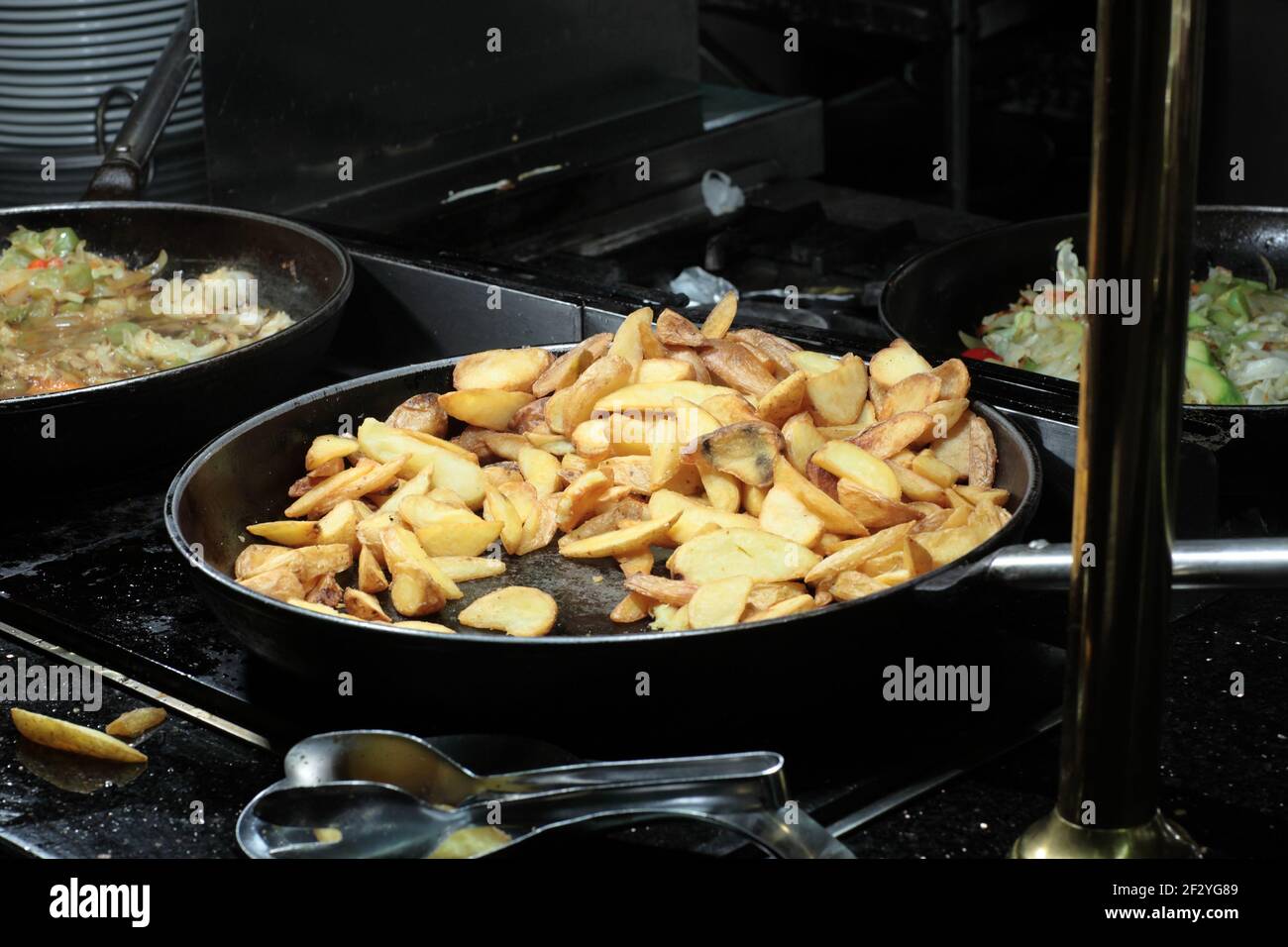 Fried potato slices in a pan at the buffet Stock Photo - Alamy