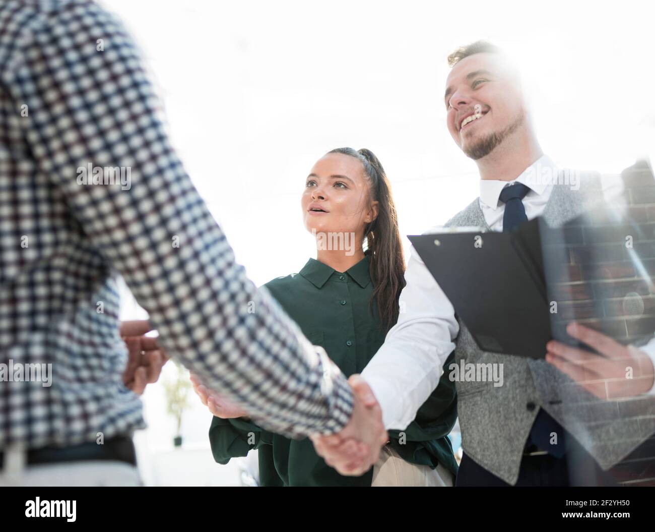 through the glass. business partners shaking hands Stock Photo - Alamy