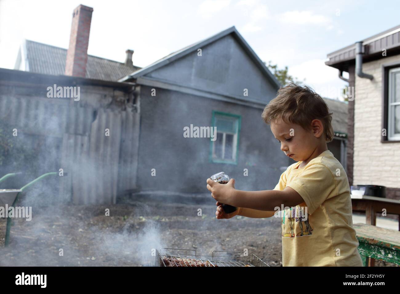 Child seasoning pork chops with pepper at the backyard Stock Photo - Alamy