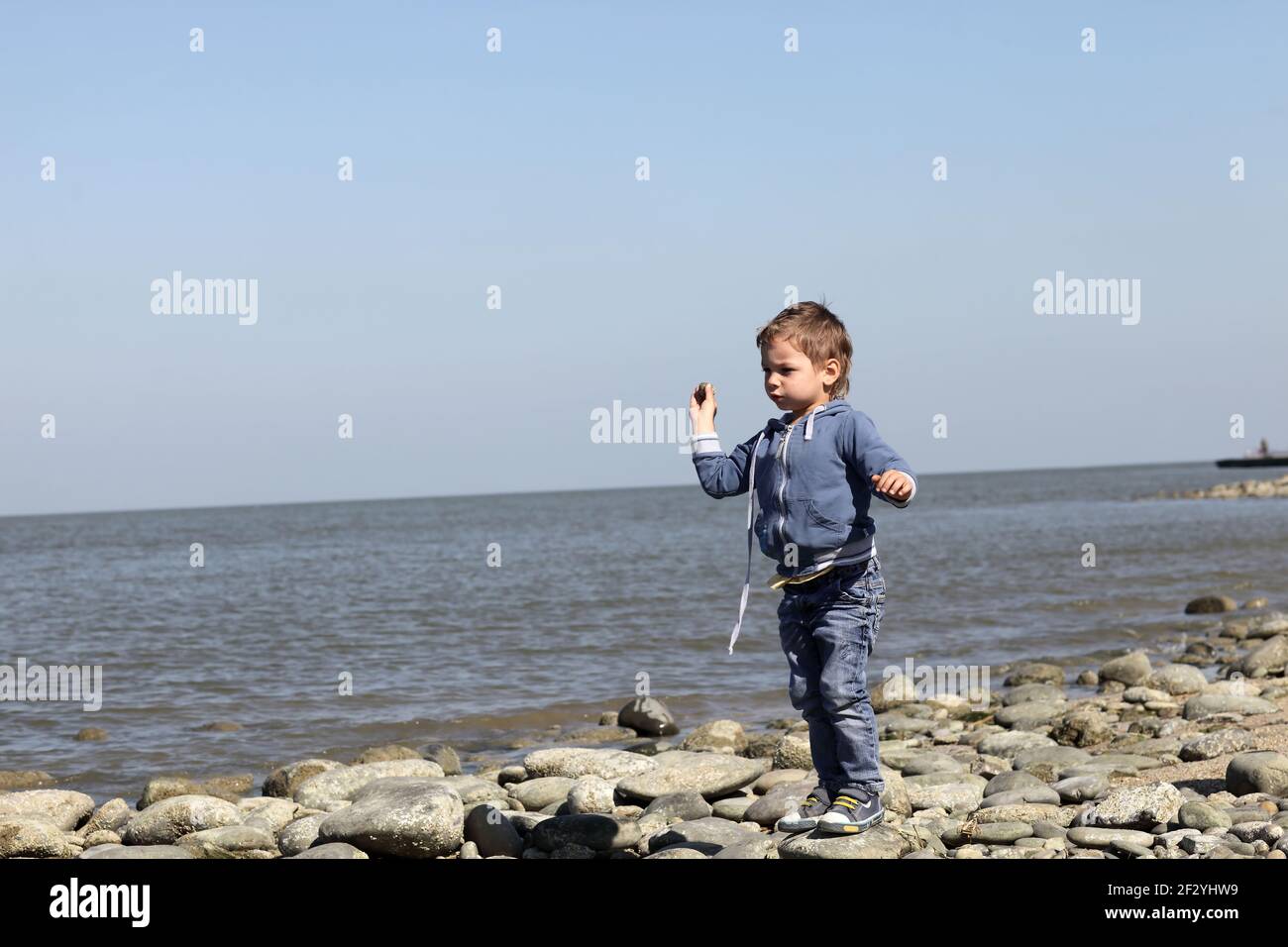 Boy Throwing Pebbles Into The Sea High Resolution Stock Photography and ...
