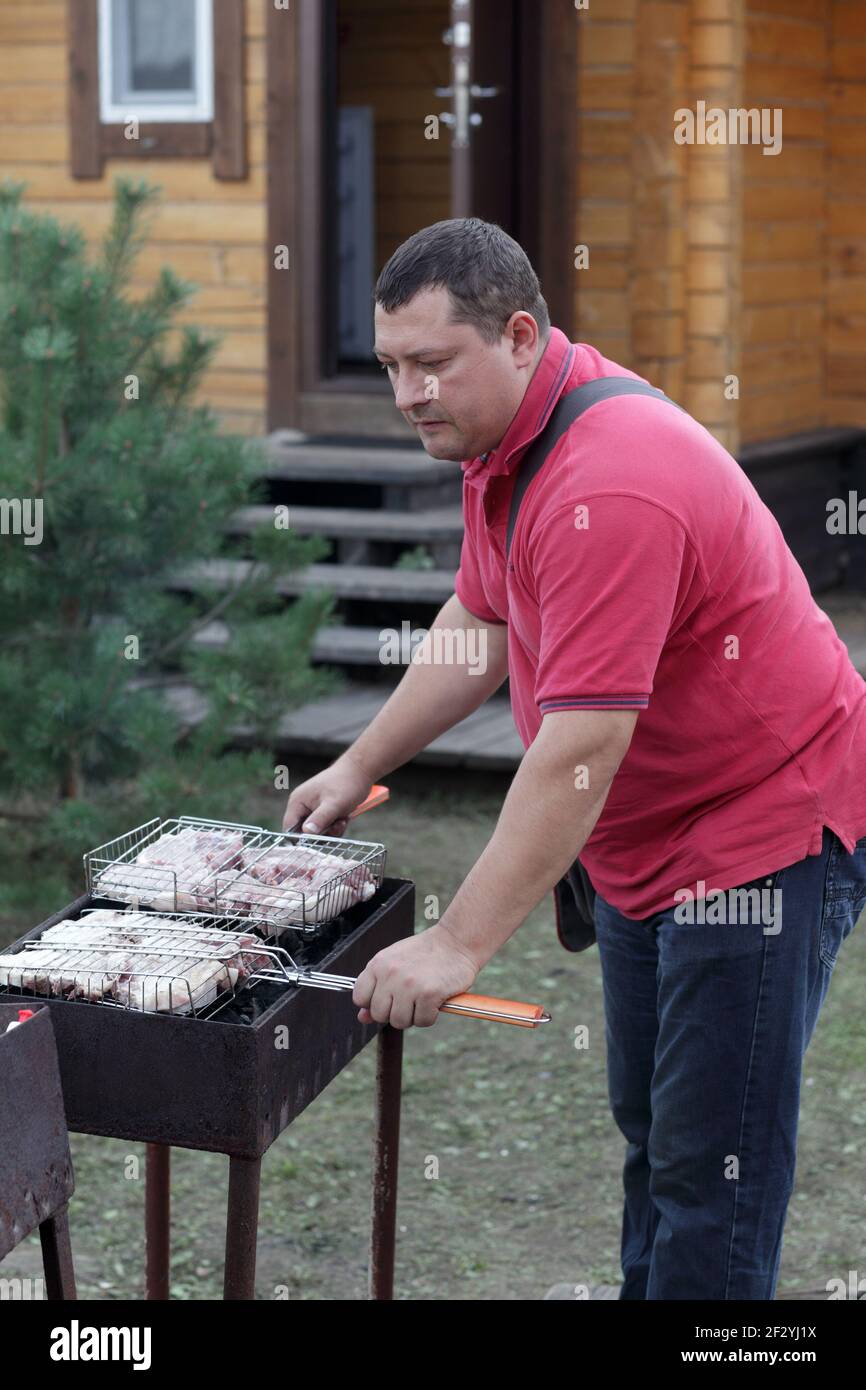 The man cooking barbecue meat at backyard Stock Photo - Alamy
