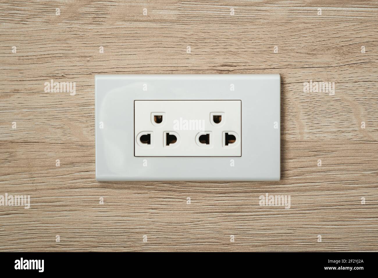 AC power plugs and sockets in wooden wall Stock Photo - Alamy