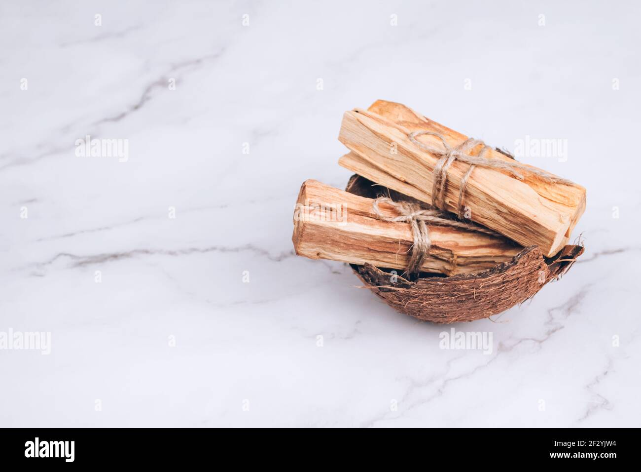 Palo Santo tree sticks inside coconut shell on marble background - holy ...
