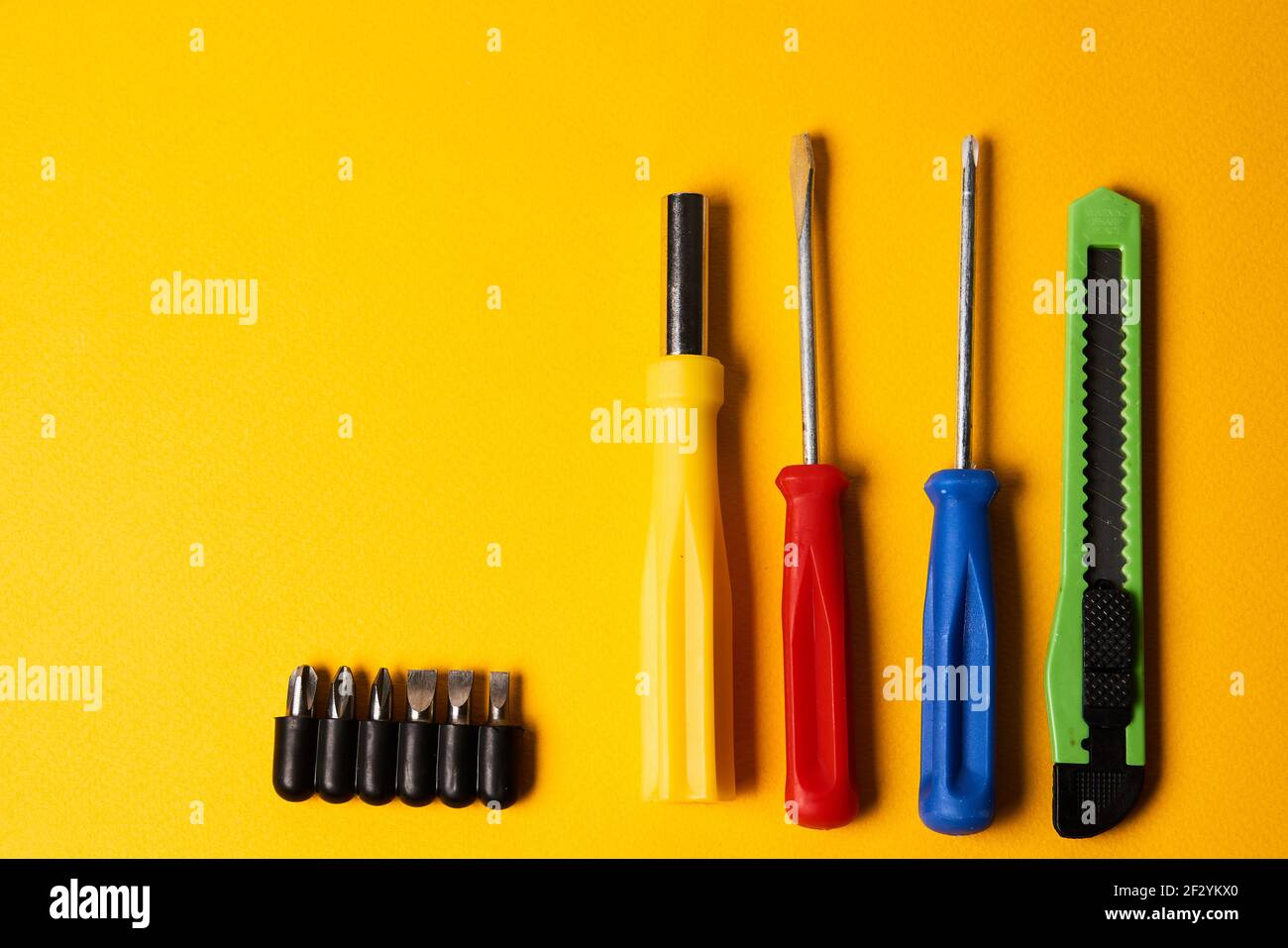Construction tools screwdriver knives nozzles repair yellow background ...