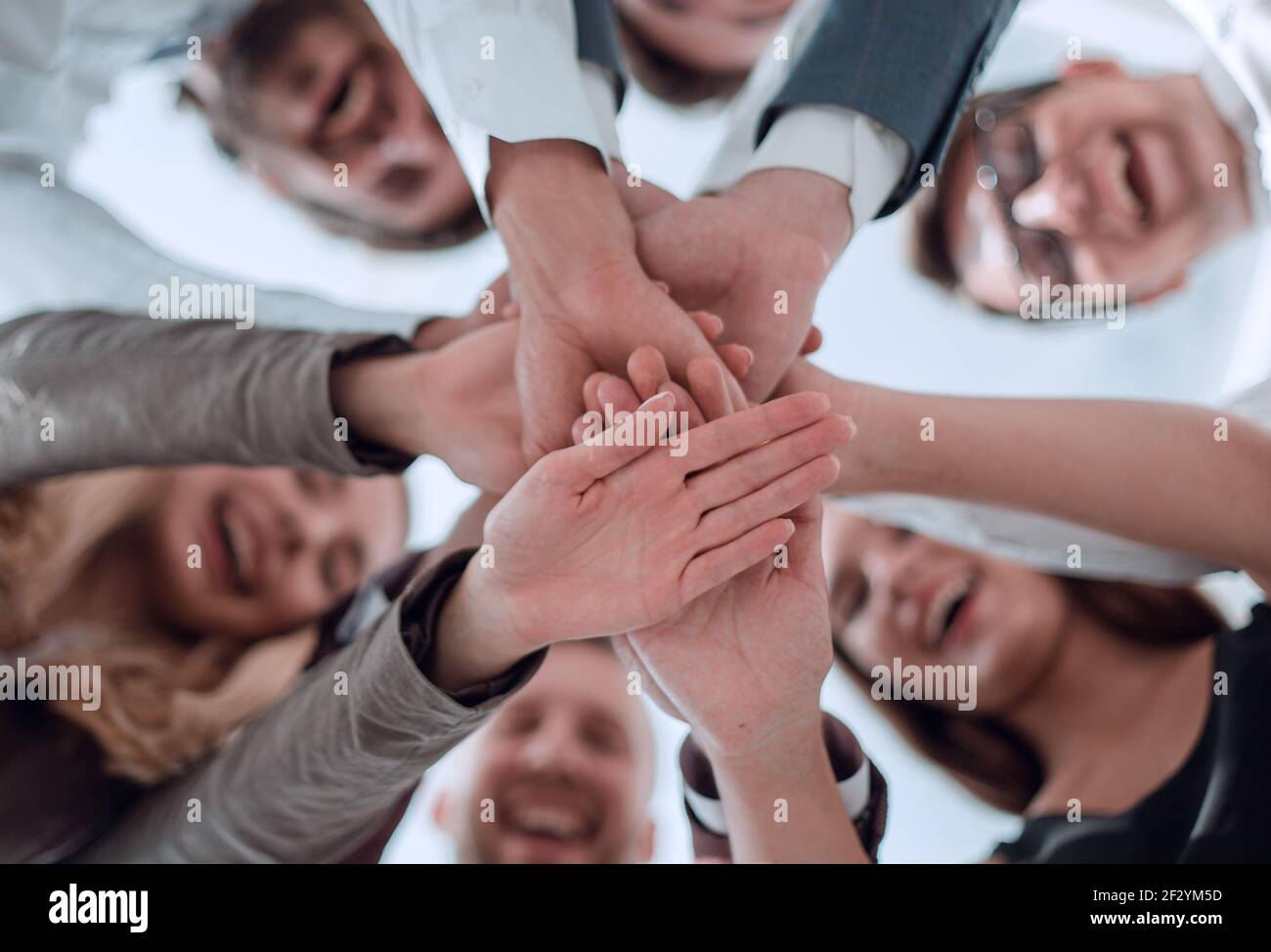 group of young business men clasping their hands together Stock Photo ...