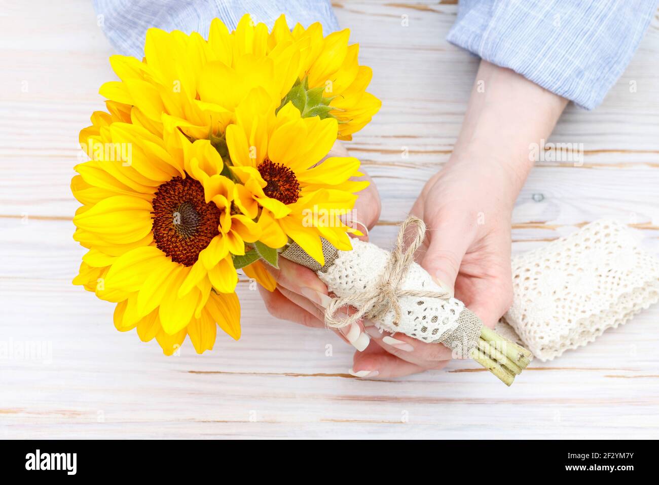 Florist at work: Woman shows how to make bouquet with sunflowers. Step ...