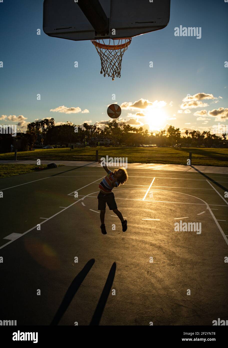 Cute little boy child jumping with basket ball for shot. Little child ...