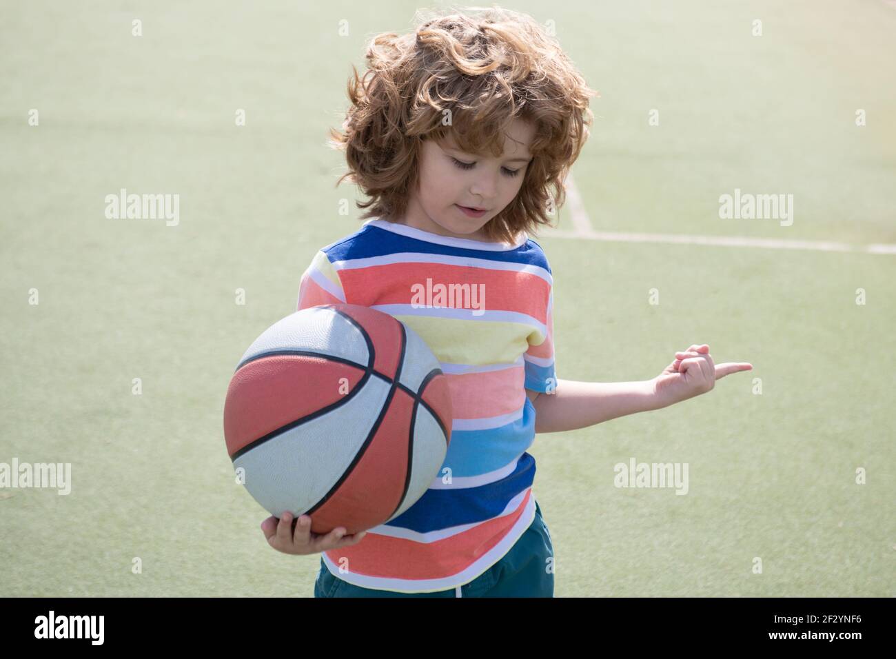 Happy little boy kid playing basketball on playground Stock Photo - Alamy