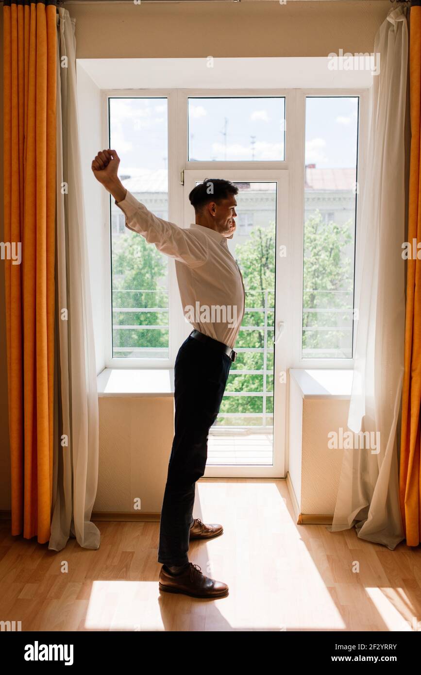 Relaxed young man resting from work. Man enjoy break stretching in home ...