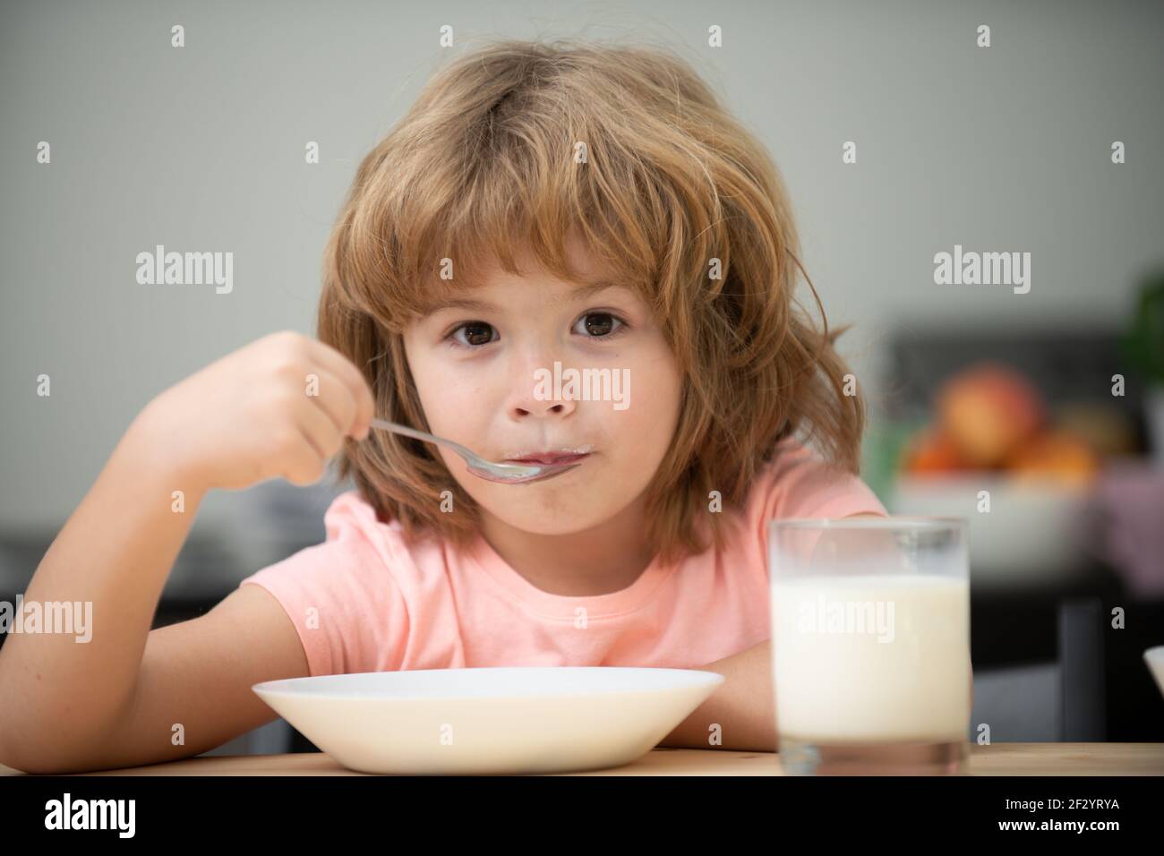 Closeup face of kid eating organic food, yogurt, milk. Child healthy ...