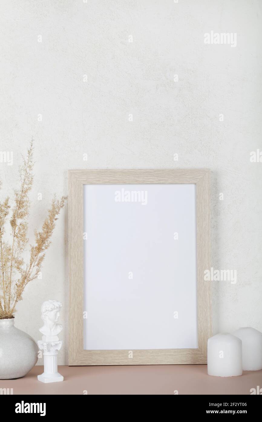Portrait empty wooden frame mockup, dried pampas grass, small statue ...