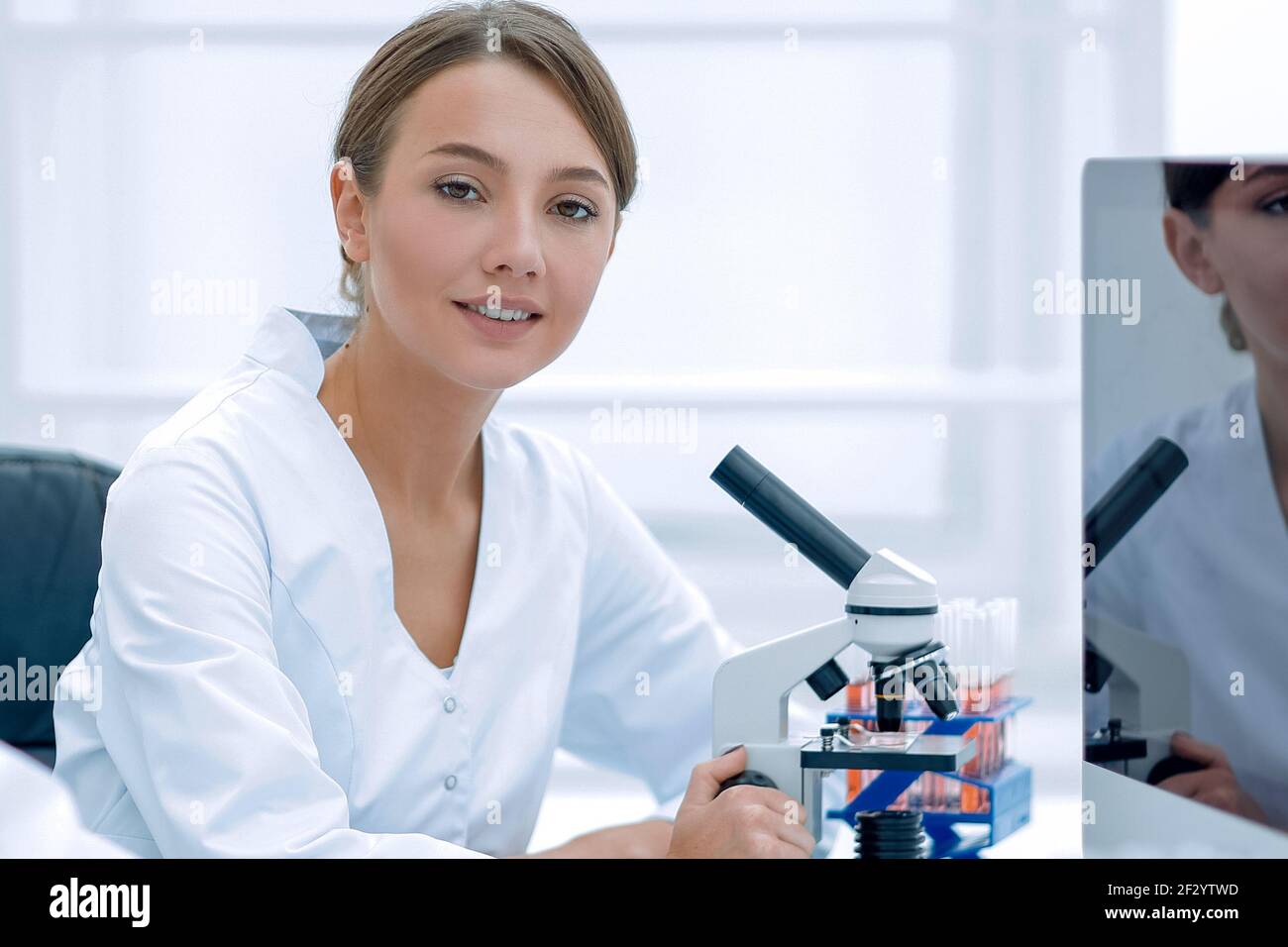Lab expert working on a test using microscope Stock Photo - Alamy