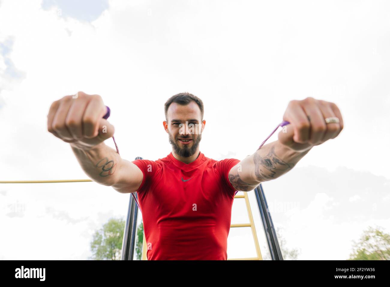Caucasian sportsman pulling up wide grip hand on crossbar during street ...