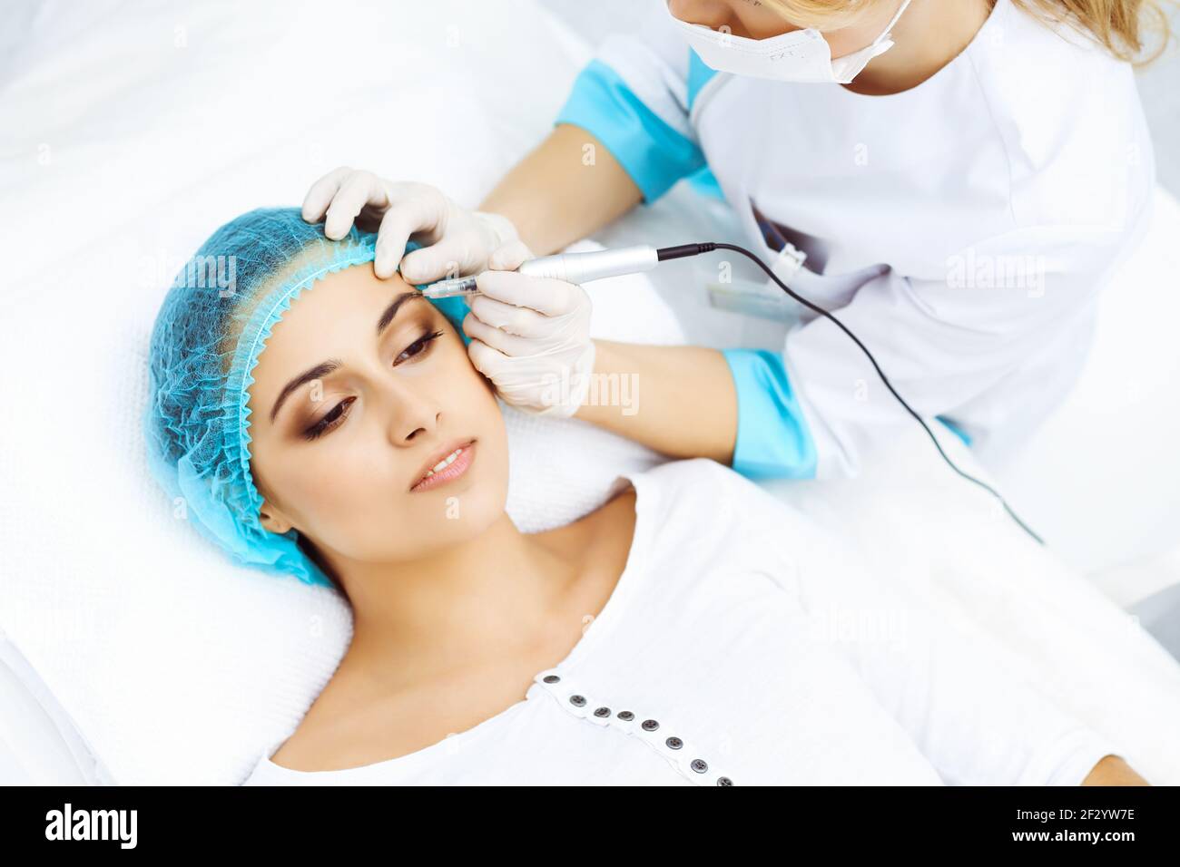 Professional beautician doing eyebrow tattoo at woman face. Permanent ...