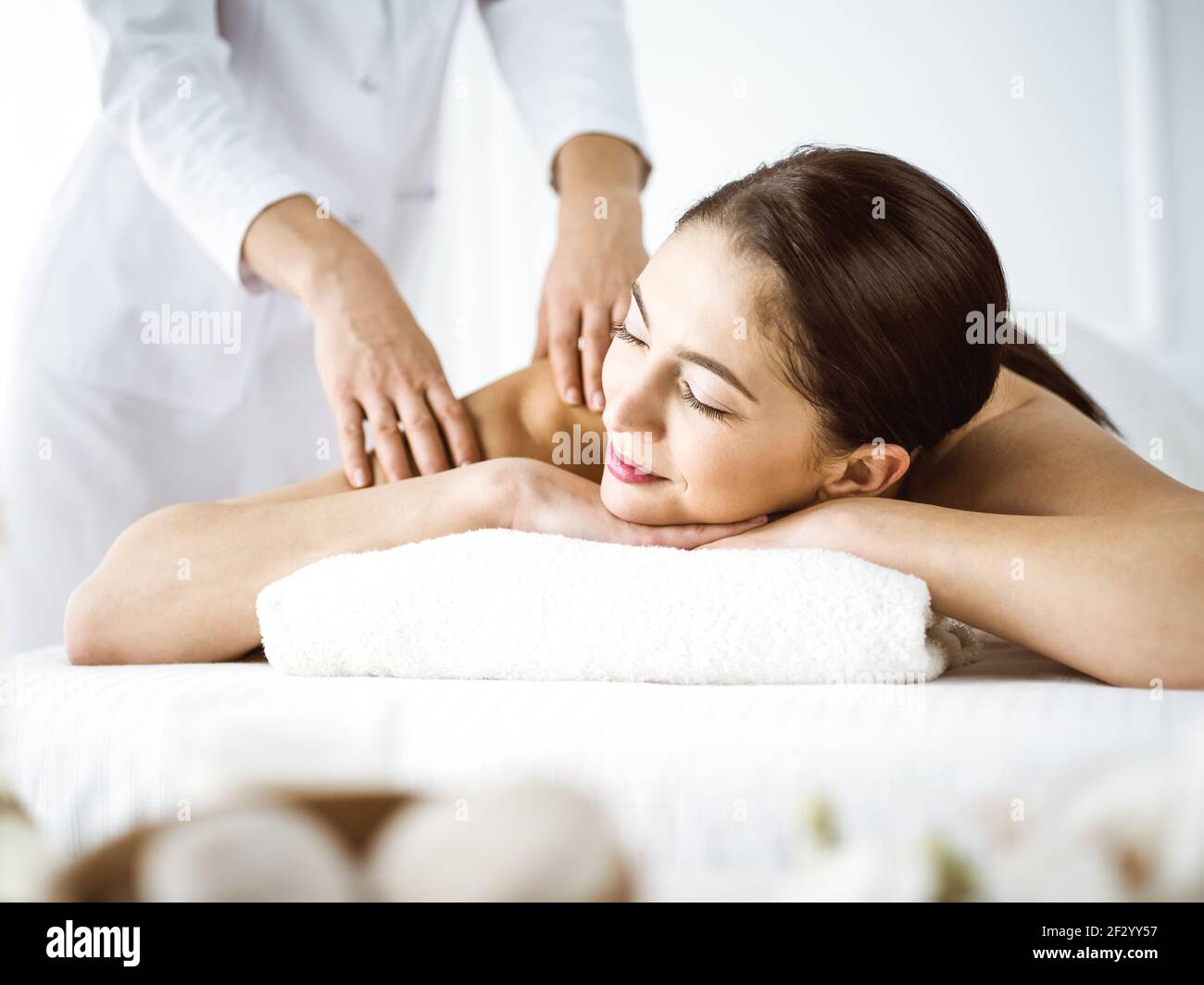Beautiful brunette woman enjoying back massage comfortable and blissful ...