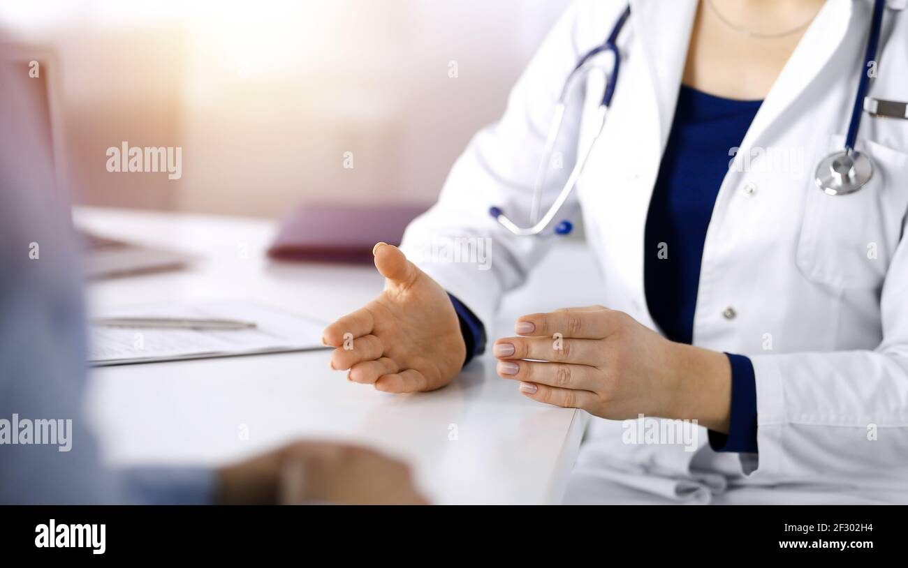 Unknown woman-doctor is talking to her patient, while they are sitting ...