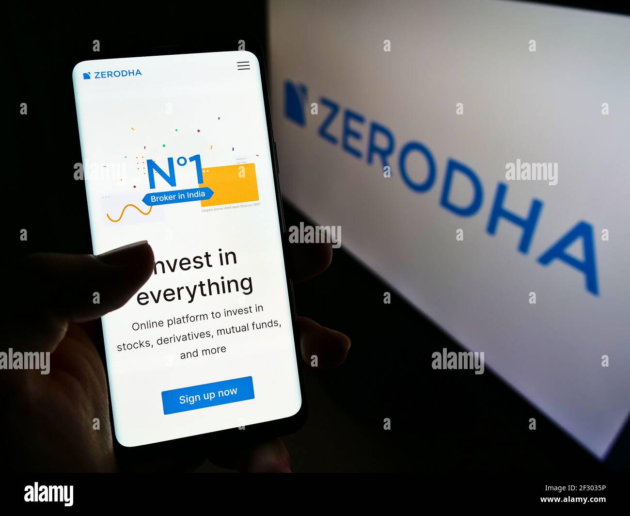 Person holding mobile phone with webpage of Indian financial company ...