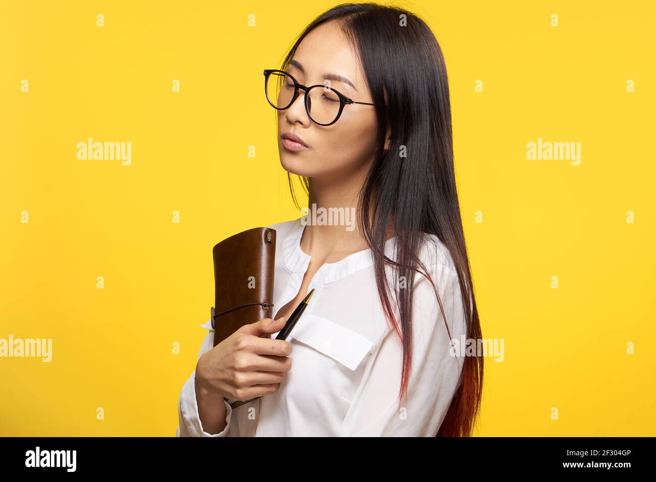 elegant woman holding notepad glasses manager executive yellow background Stock Photo - Alamy
