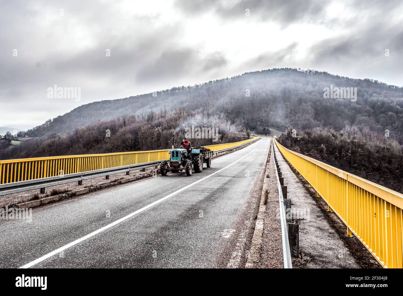 Farmer driving a tractor on the road Stock Photo - Alamy