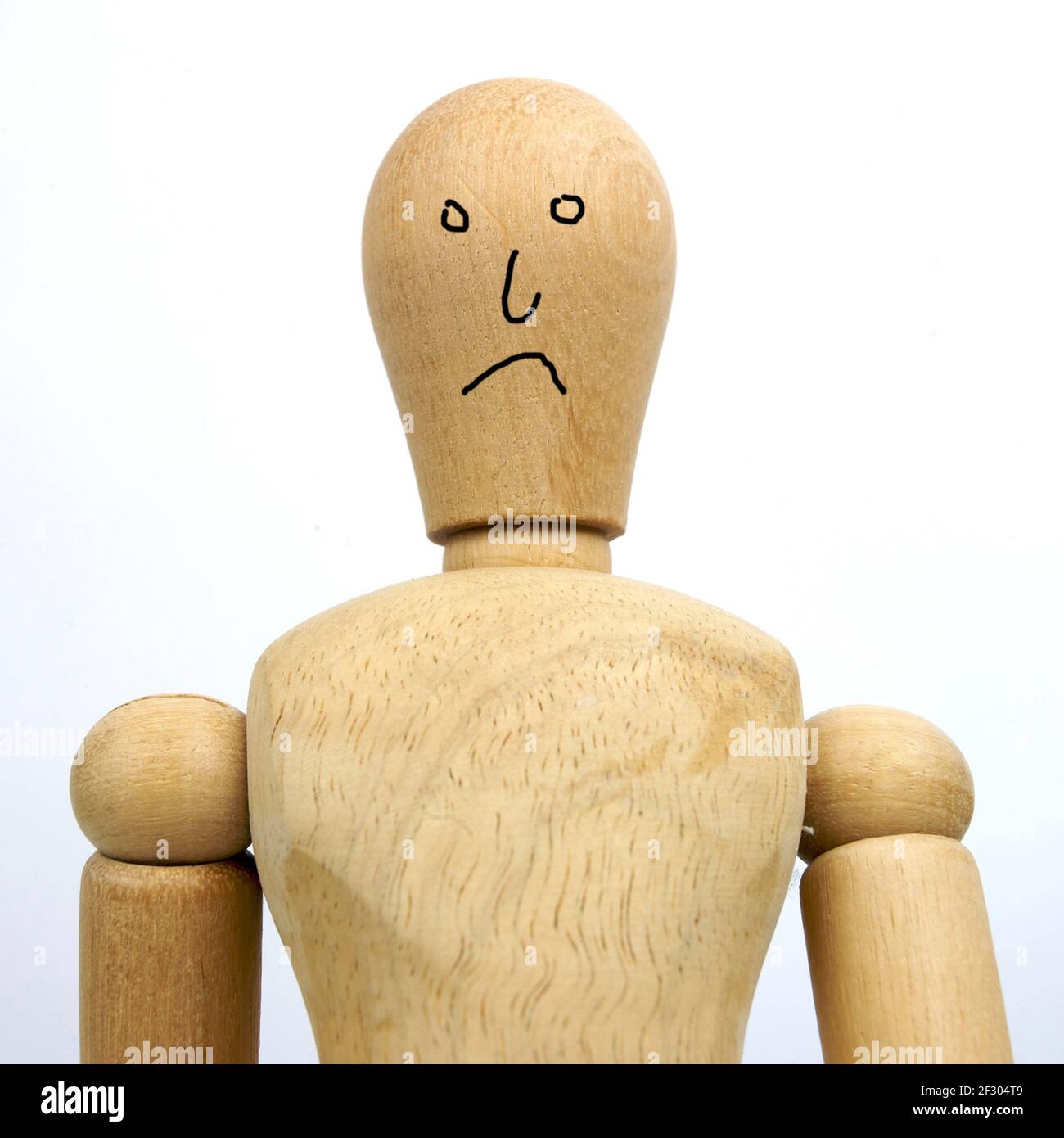 A closeup shot of a sad wooden figurine isolated on a white background ...