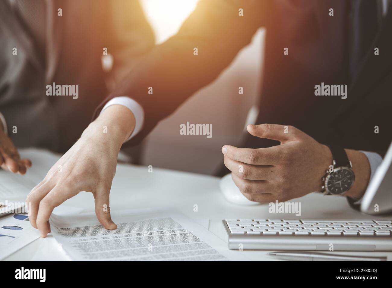 Business people using computer while working together in sunny office ...