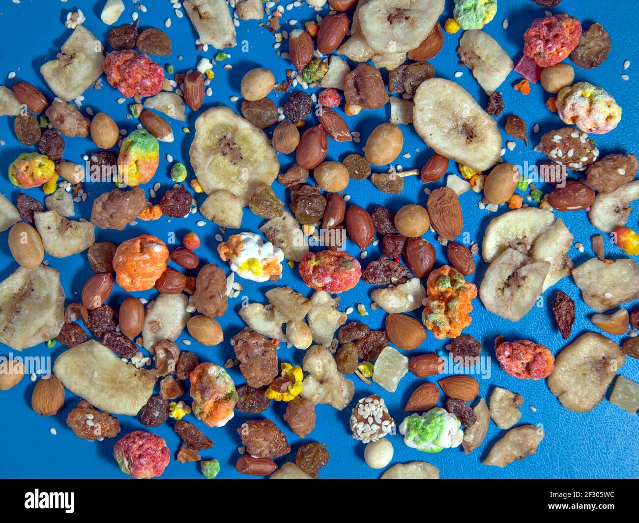 Colorful nuts are scattered on blue surface of table Stock Photo - Alamy