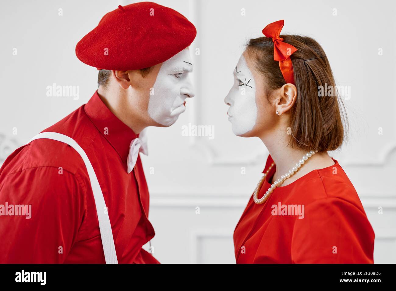Mime artists in red costumes look at each other Stock Photo - Alamy