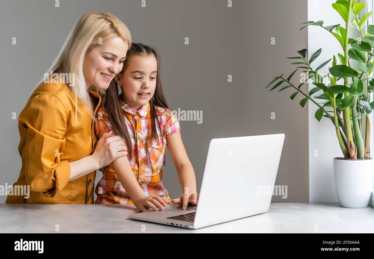 Helpful mother explaining to daughter about using a laptop Stock Photo ...
